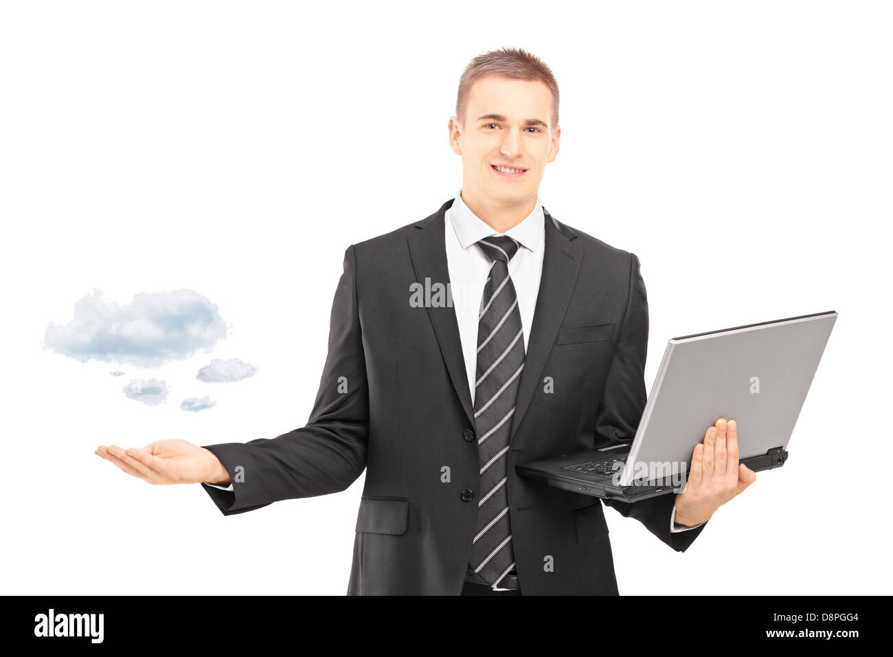 Young man in a suit holding a laptop and gesturing with his hand ...