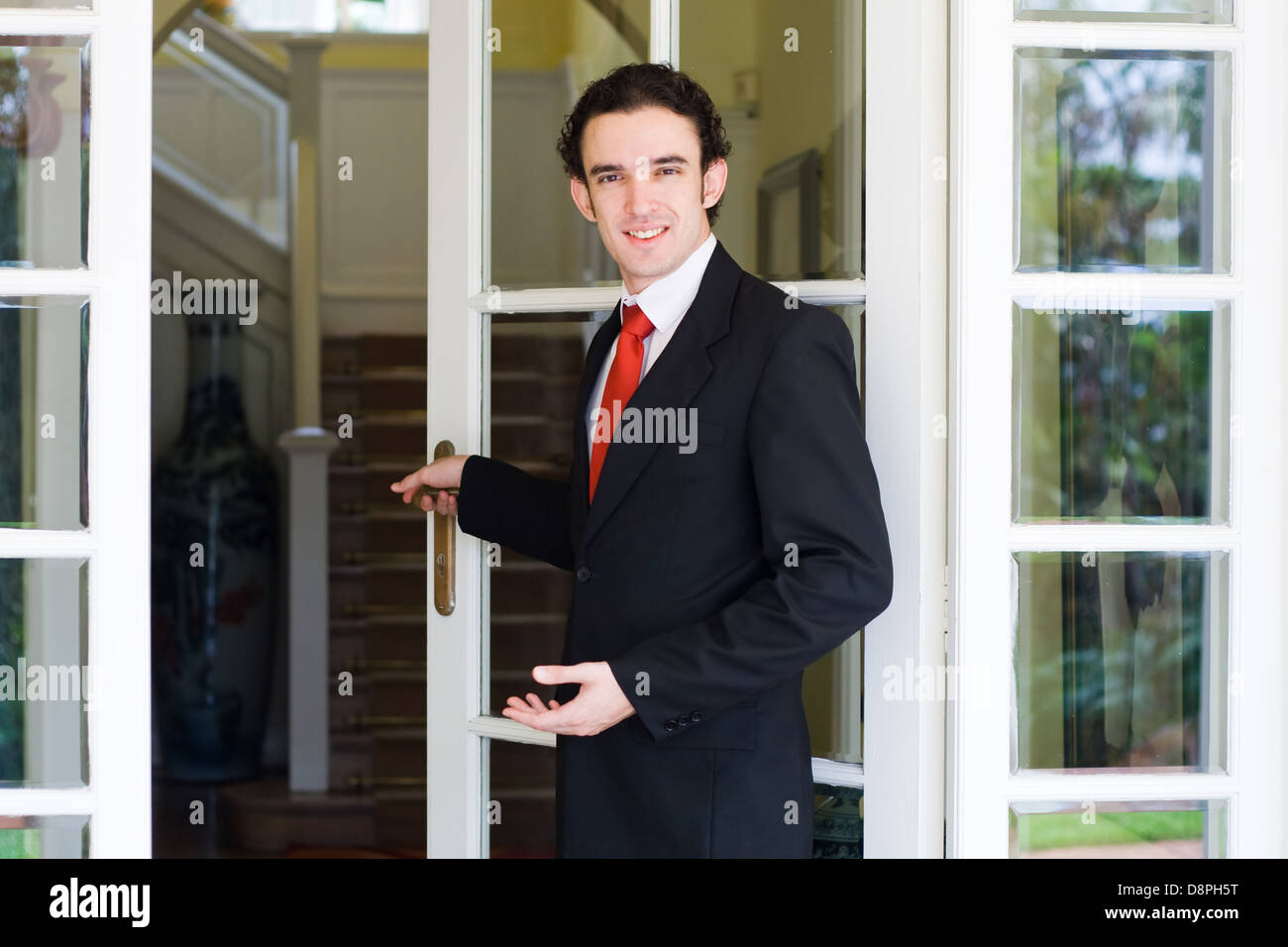young male real estate agent welcomes client to visit Stock Photo - Alamy