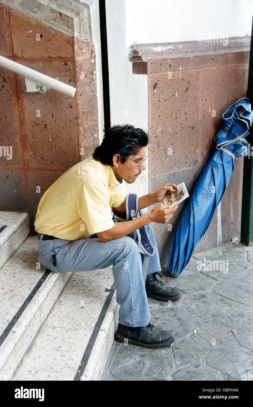 Seated Mexican man reading a comic book in Merida, Yucatan, Mexico ...