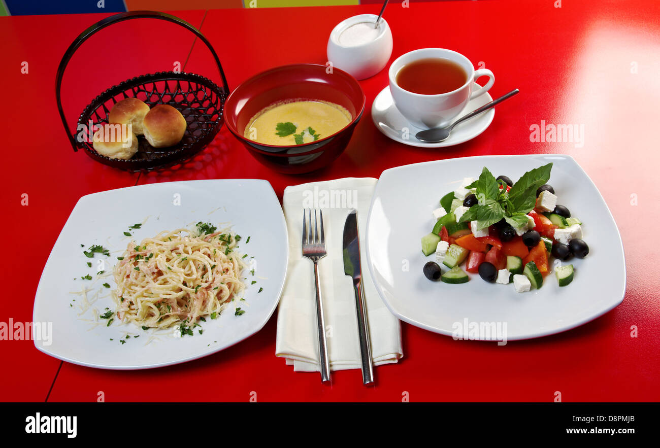 european food style.lunch greek salad , spaghetti and tea with bun ...