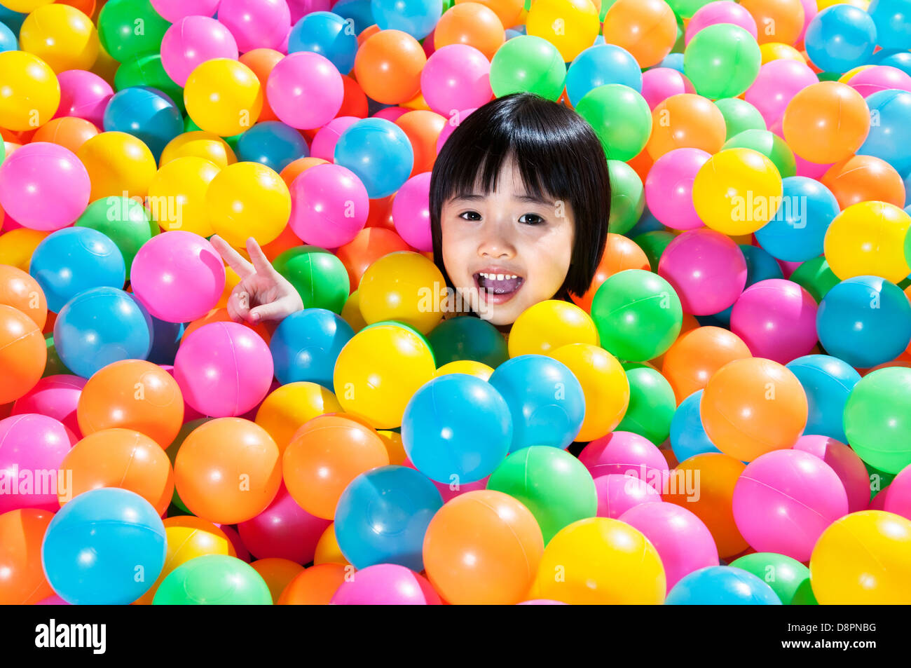 Happy young girl playing with colorful balls, portrait Stock Photo - Alamy