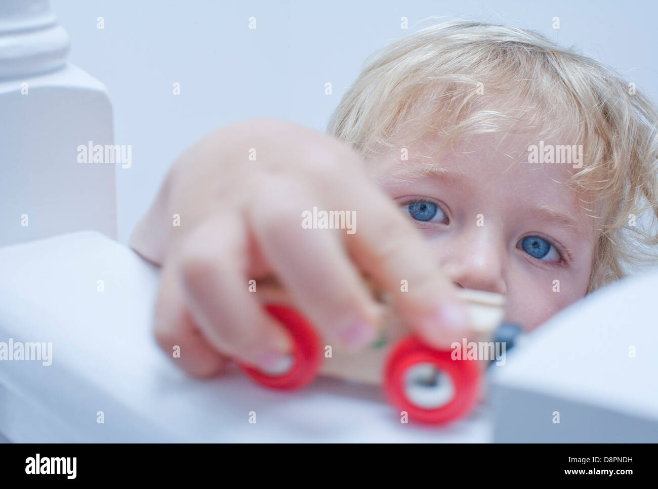 Little boy playing toy car on banister Stock Photo - Alamy