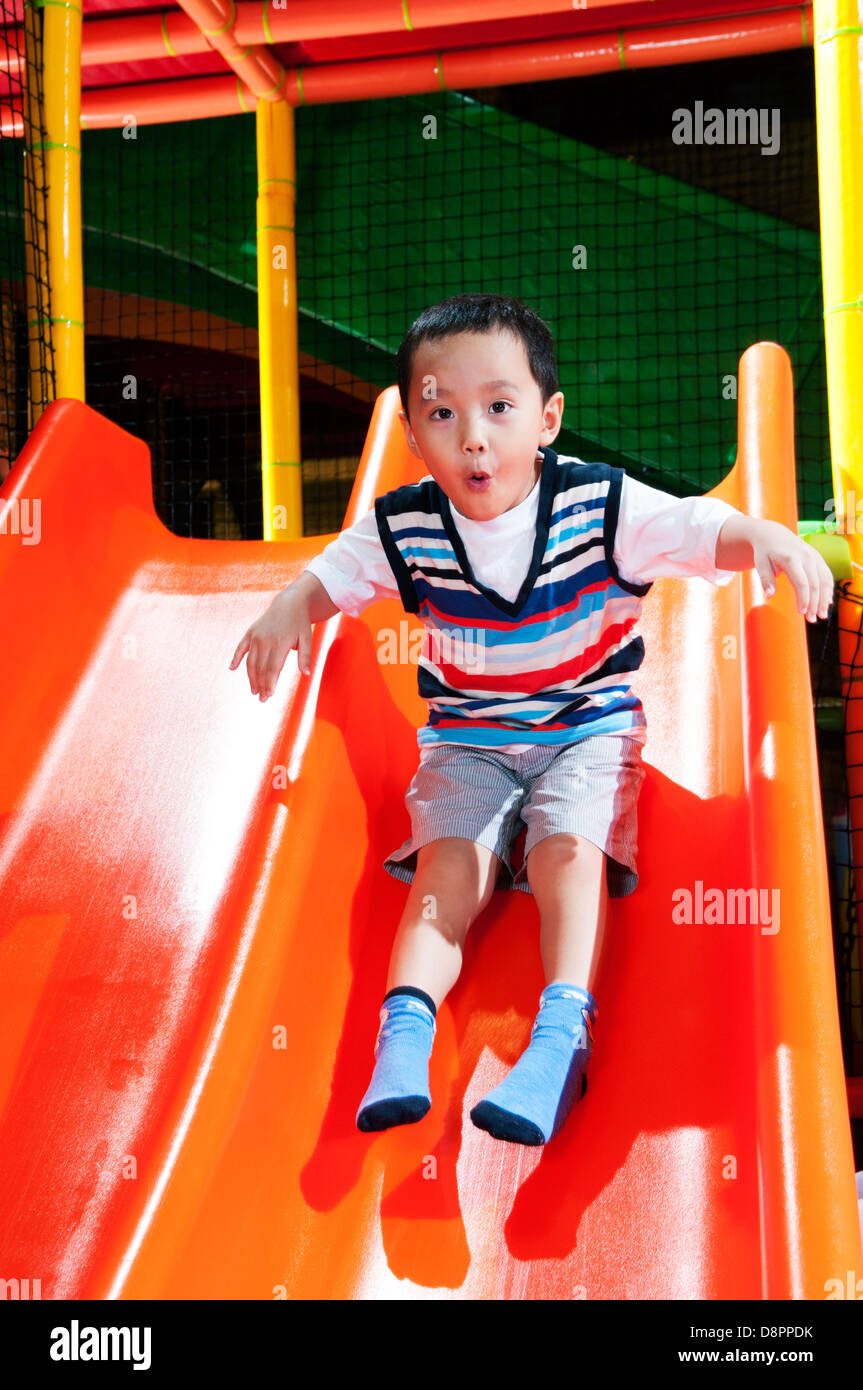 Young boy playing on a slide, portrait Stock Photo - Alamy