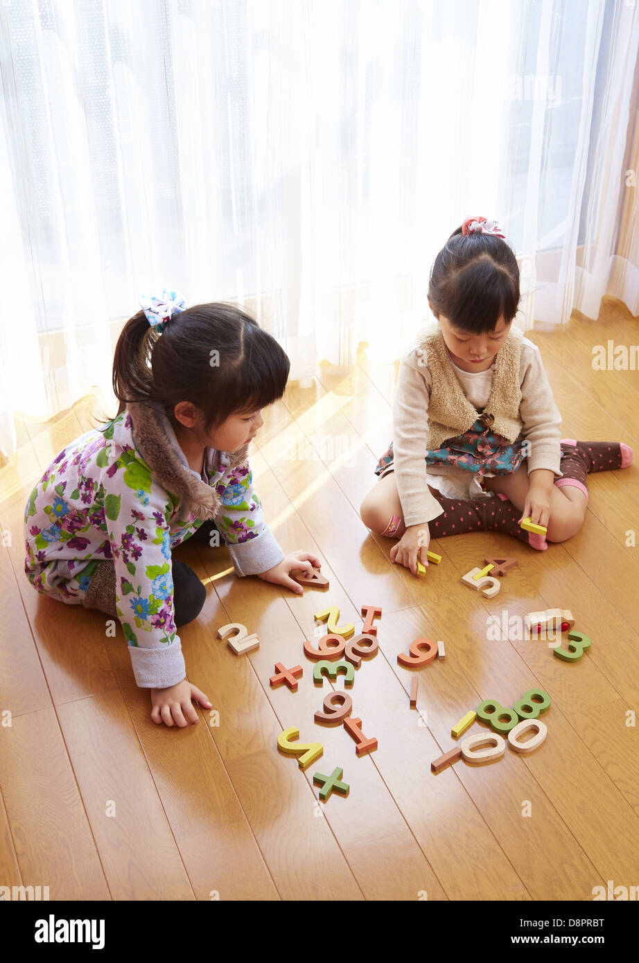 Sisters playing with number blocks Stock Photo - Alamy