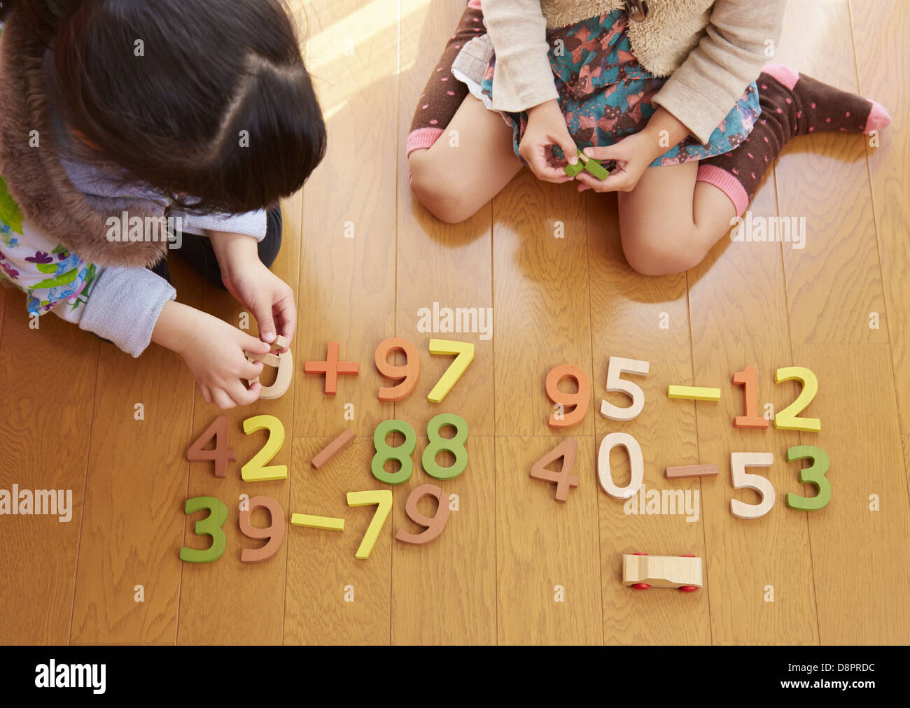 Sisters playing with number blocks Stock Photo - Alamy