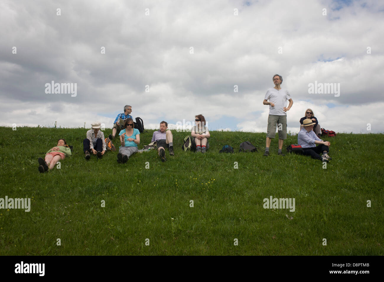 A group of country ramblers rest for lunch on the sea defence ...