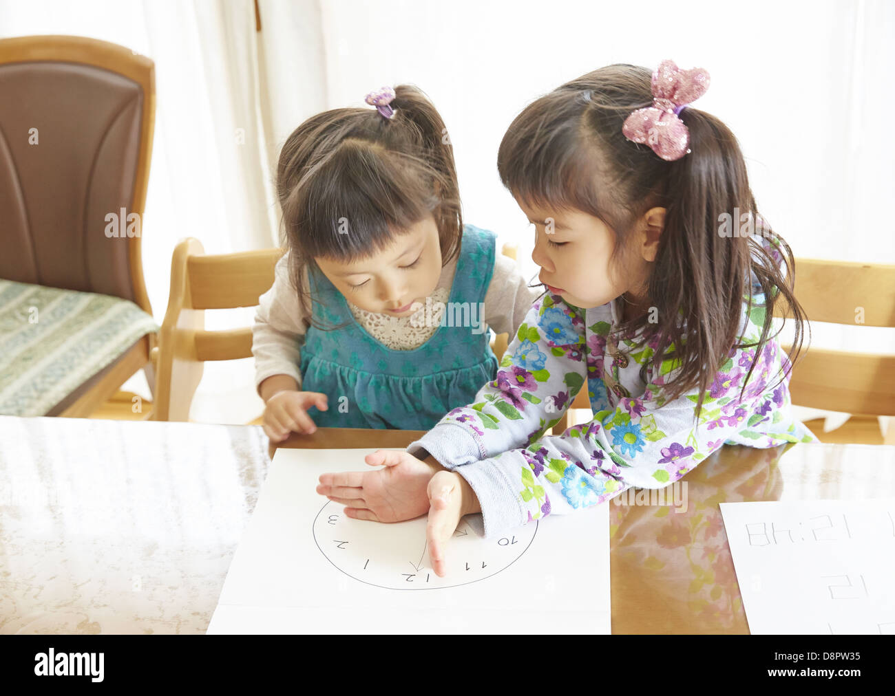 Sisters learning how to tell time Stock Photo - Alamy
