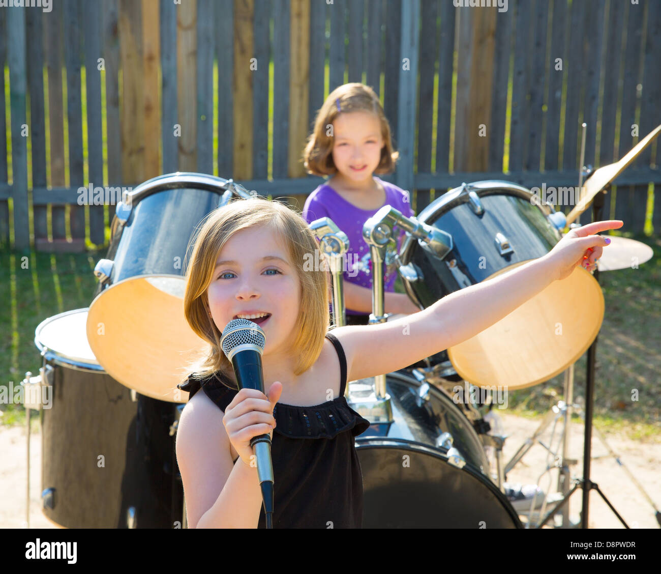 Blond kid singer girl singing playing live band in backyard concert ...