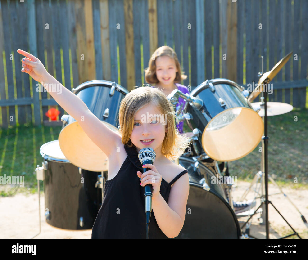 Blond kid singer girl singing playing live band in backyard concert ...