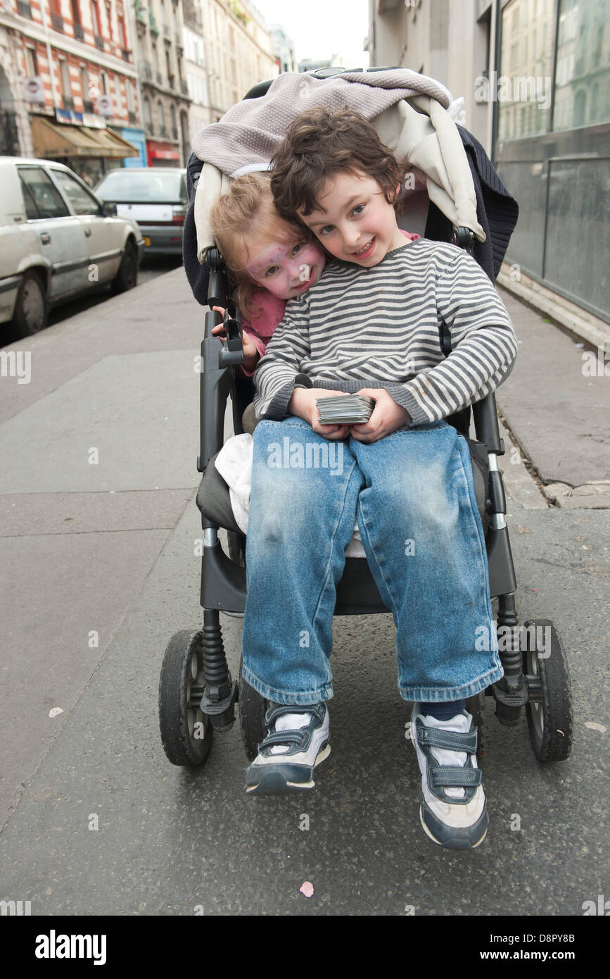 Young siblings sitting together in stroller Stock Photo - Alamy