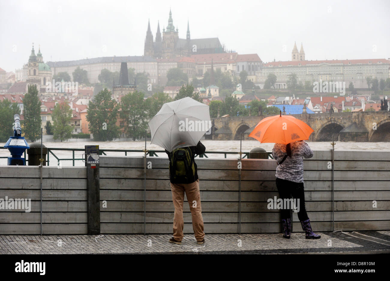 A couple watches the swollen Vltava river toward Prague´s Castle over ...