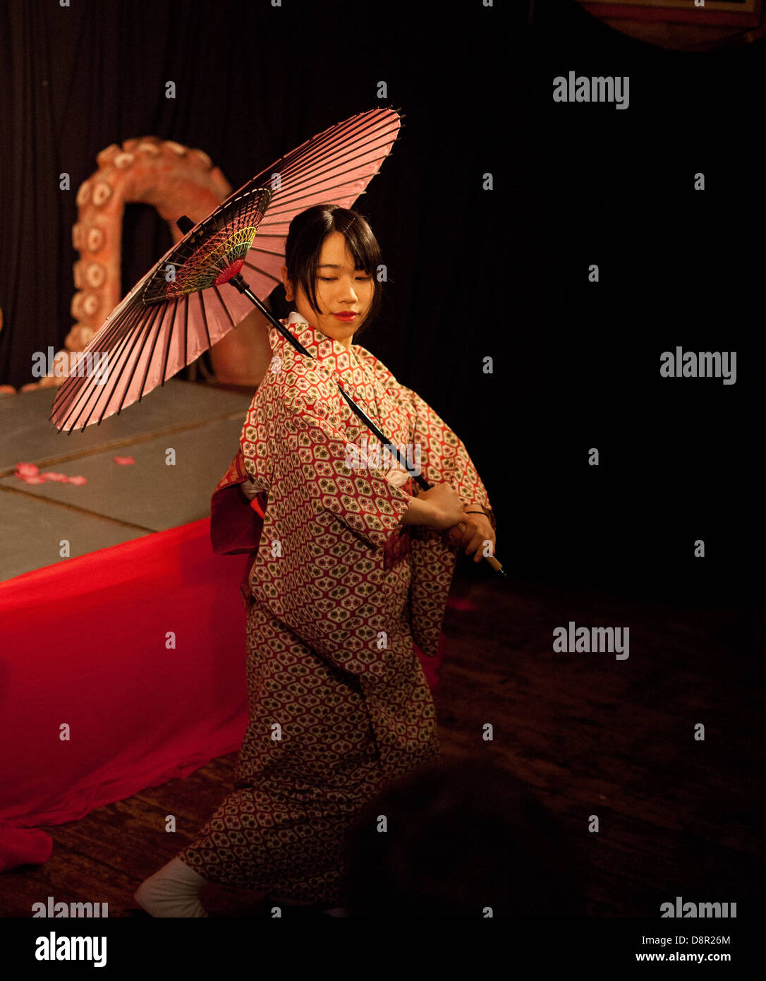 Young Japanese woman performs a traditional Japanese dance with parasol ...