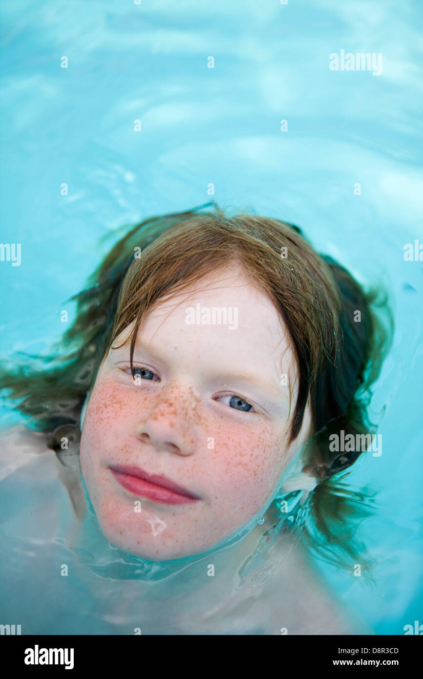 Young boy floating in pool Stock Photo - Alamy