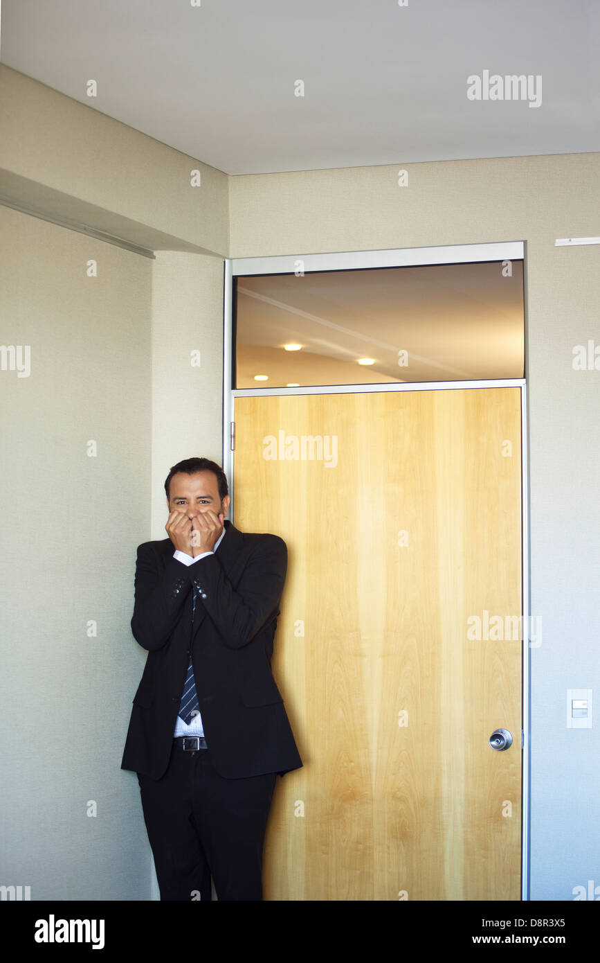 Businessman standing in corner with terrified expression Stock Photo ...
