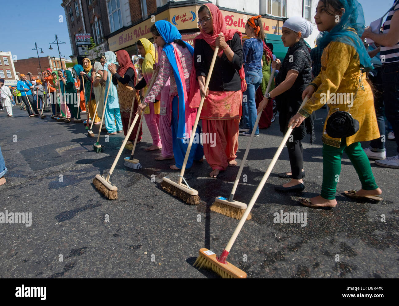 Sweepers clean the way before the procession of the holy book and men ...
