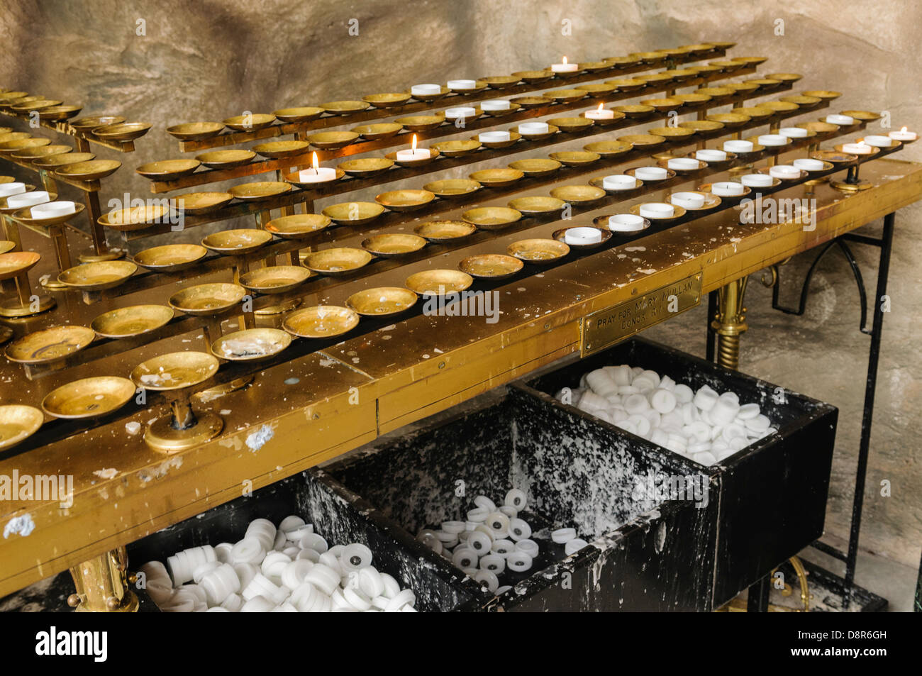 Candles in the corner of a Catholic grotto shrine Stock Photo - Alamy