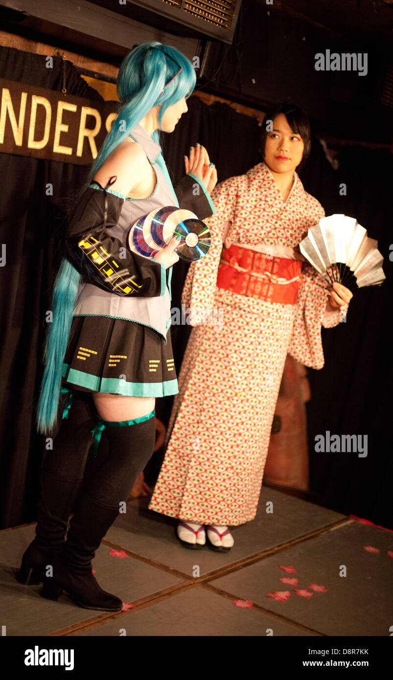 Young Japanese woman and cosplay anime performer pose for artists at a ...