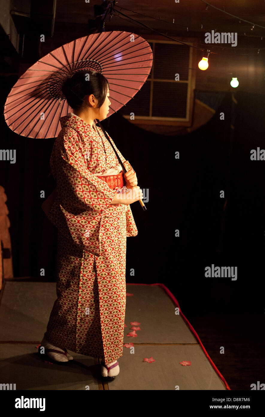 Young Japanese woman performs a traditional Japanese dance in a kimono ...