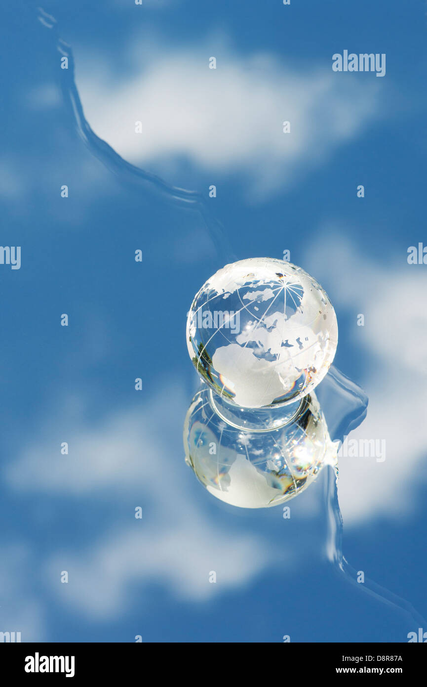 Crystal Glass globe / earth / world on a mirror with water reflecting ...