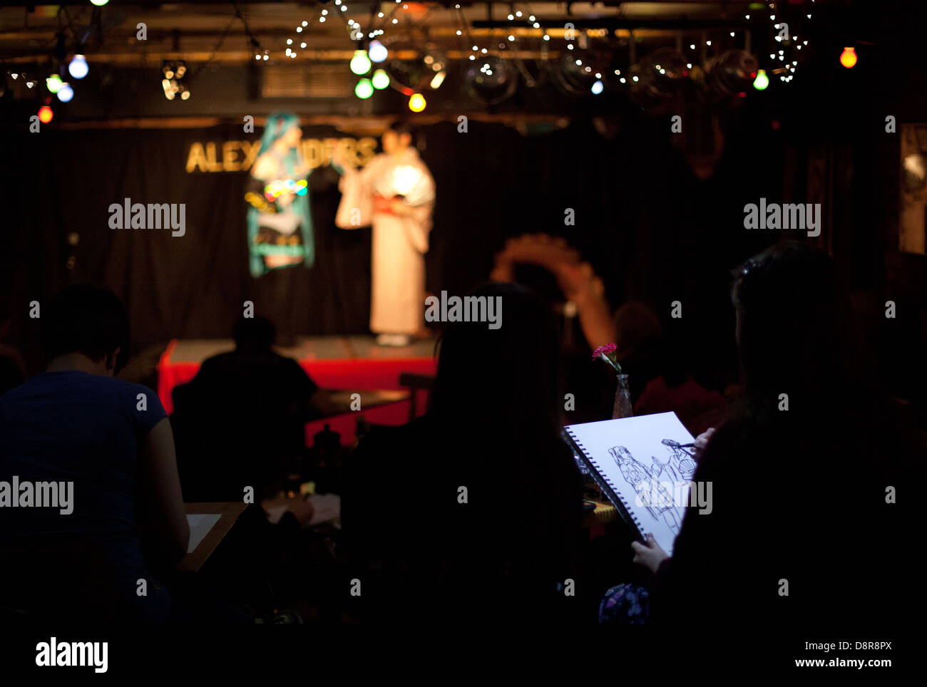 Young Japanese woman and cosplay anime performer pose for artists at a ...