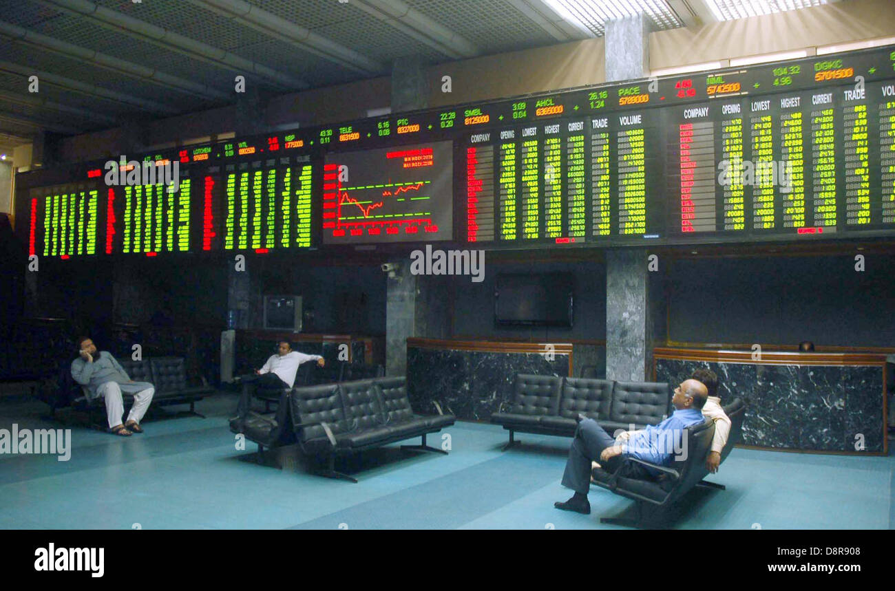 Pakistani traders sit beneath an electronic screen at the Karachi Stock ...