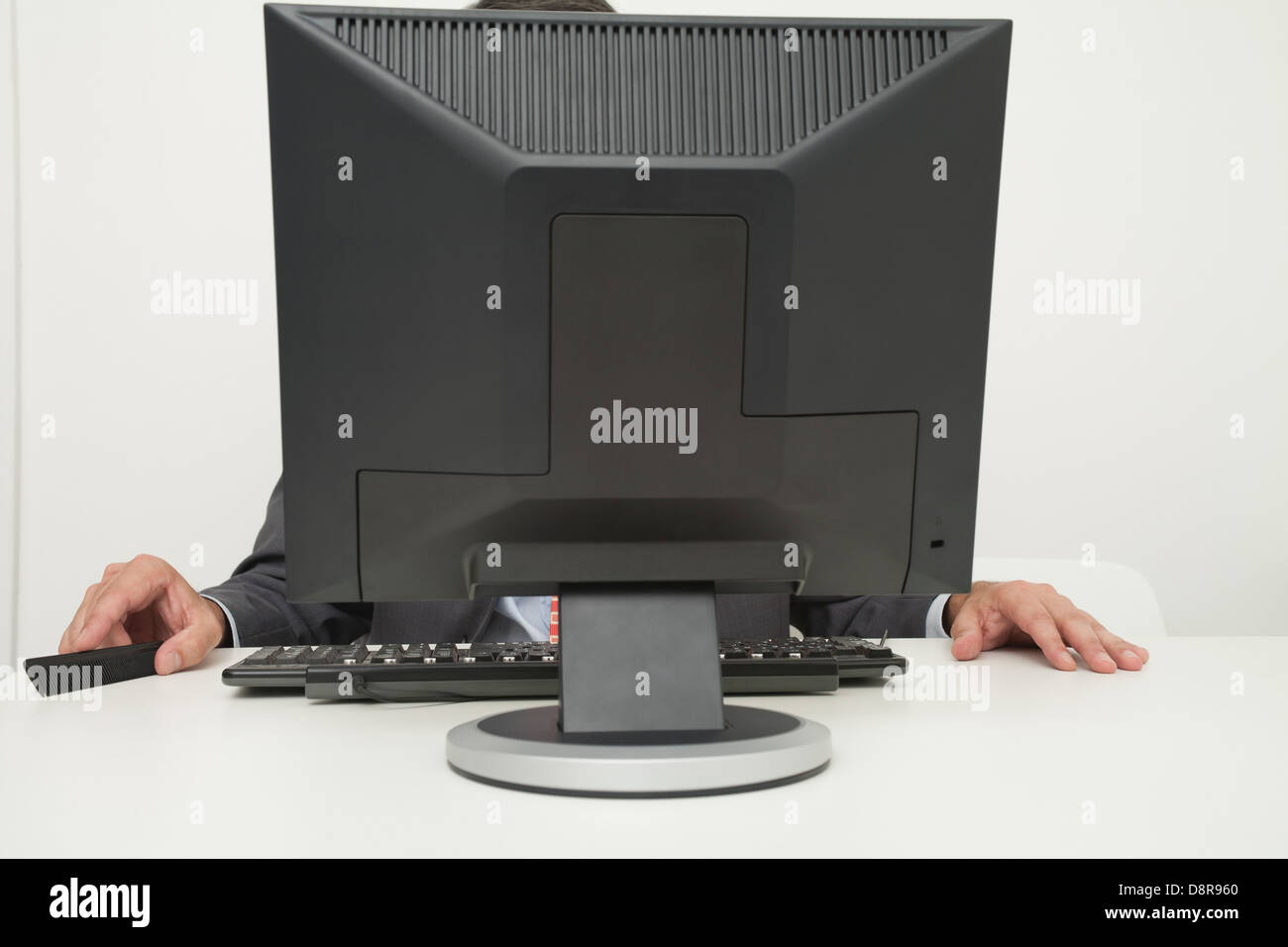 Man sitting in front of computer monitor Stock Photo - Alamy