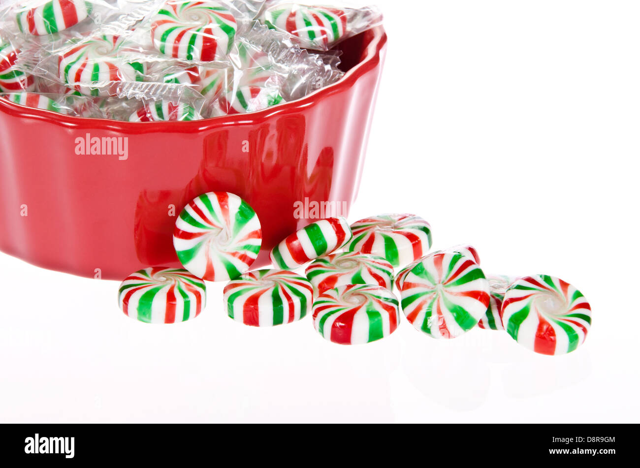 Peppermint candies and red bowl over white Stock Photo - Alamy