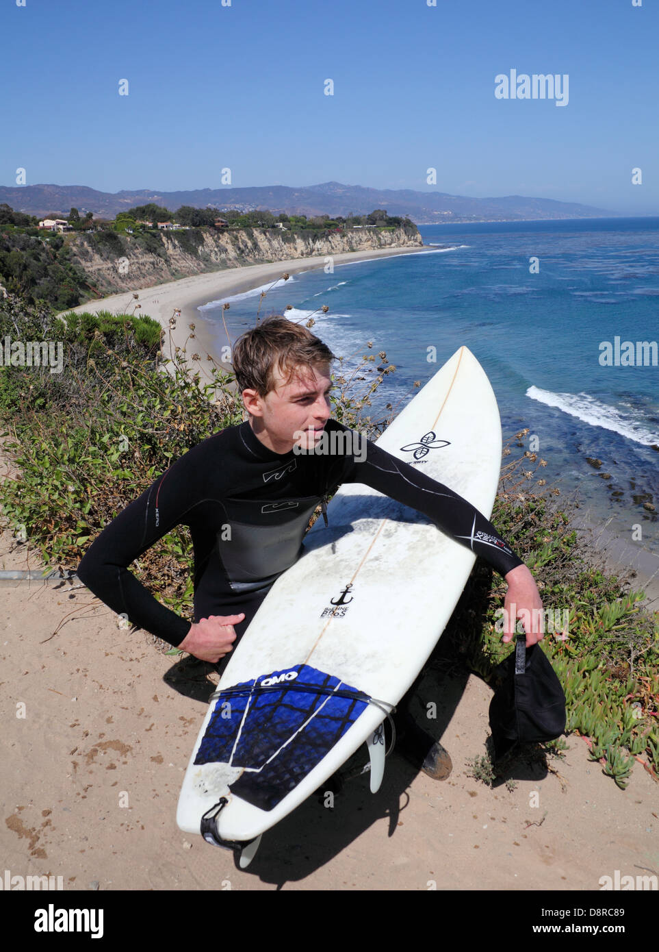 Surfer looks at waves from trail leading to Point Dume State Beach at ...
