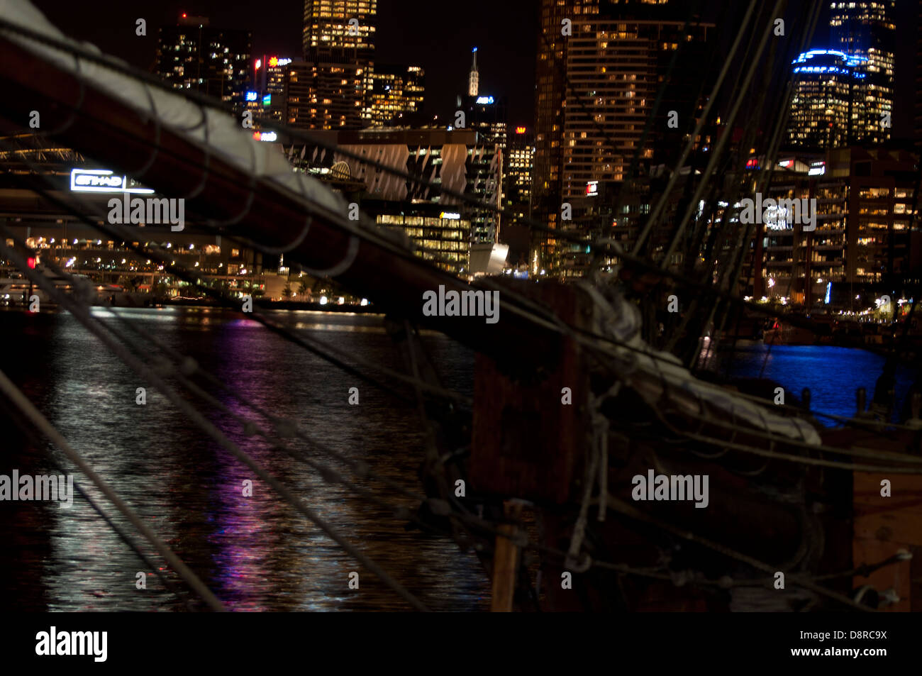 clipper sailing ship moody night light with city lights background ...