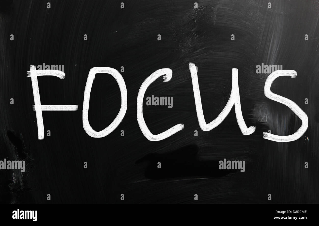 The word "Focus" handwritten with white chalk on a blackboard Stock ...