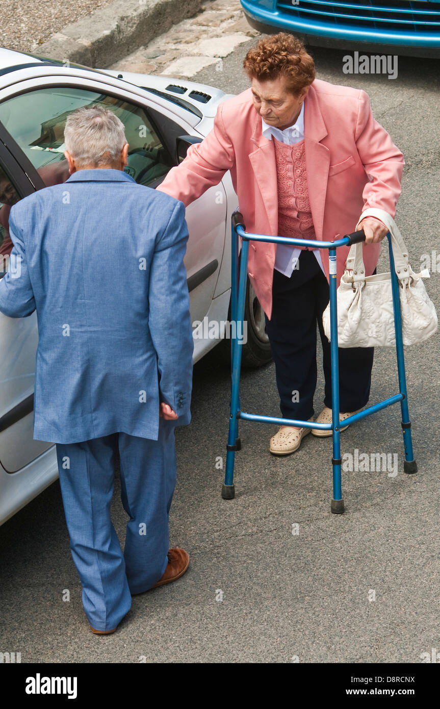 Overhead view of elderly couple / woman with walking frame getting into ...