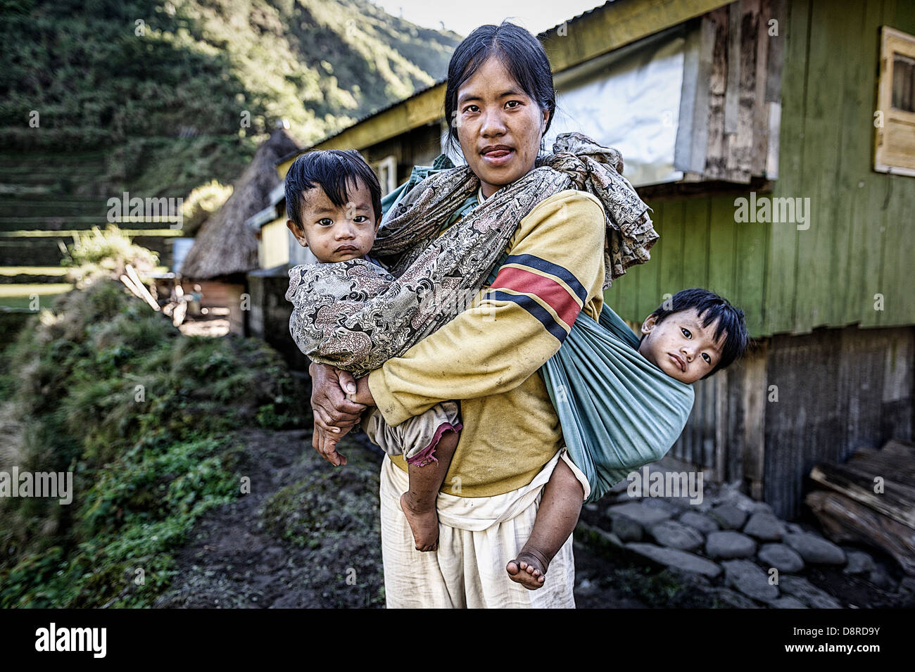 Woman carrying her two sons with a cloth on her shoulders, Luzon ...