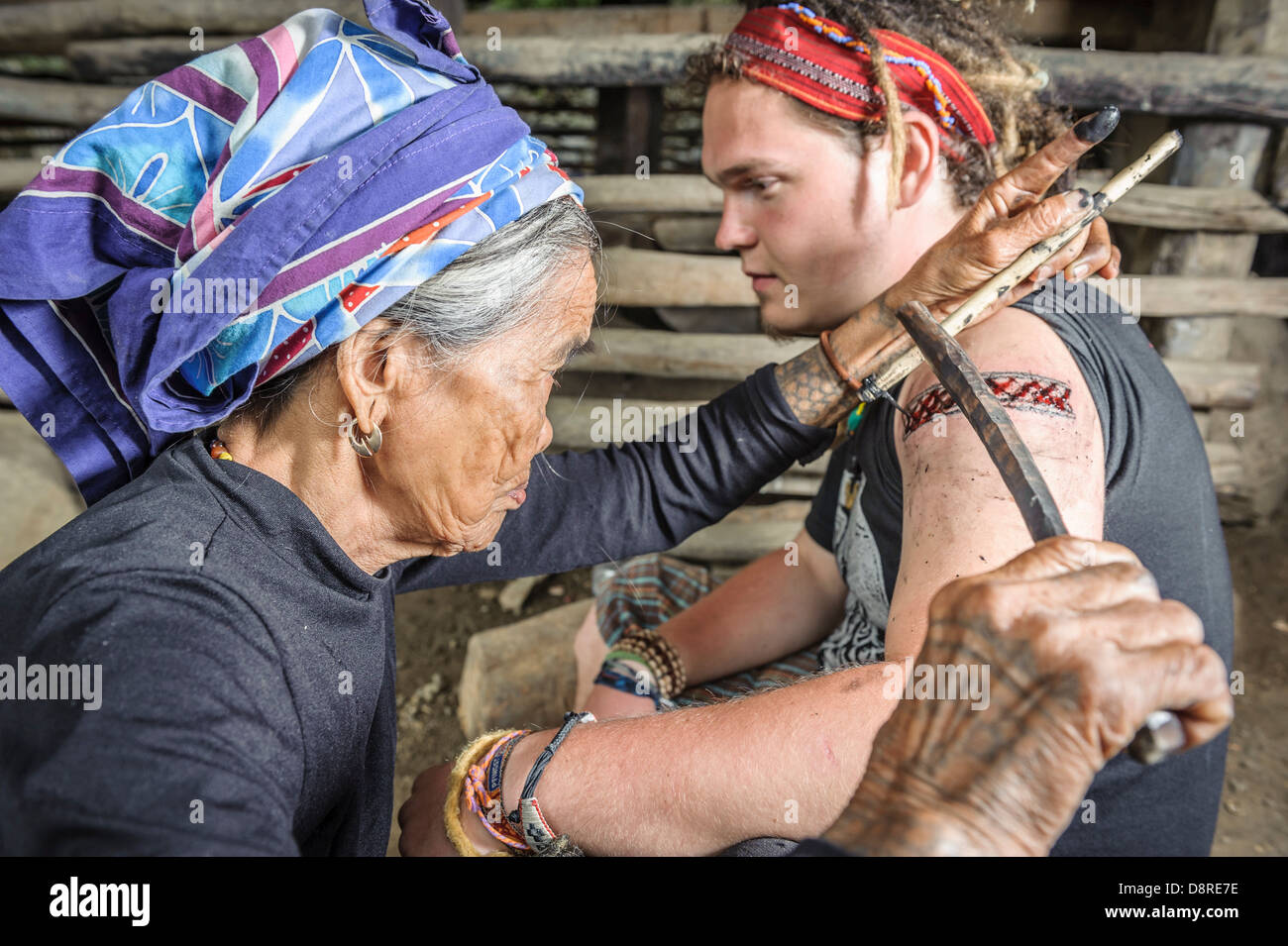 Woman tattooing a tourist in a traditional way, Kalinga, Philippines ...