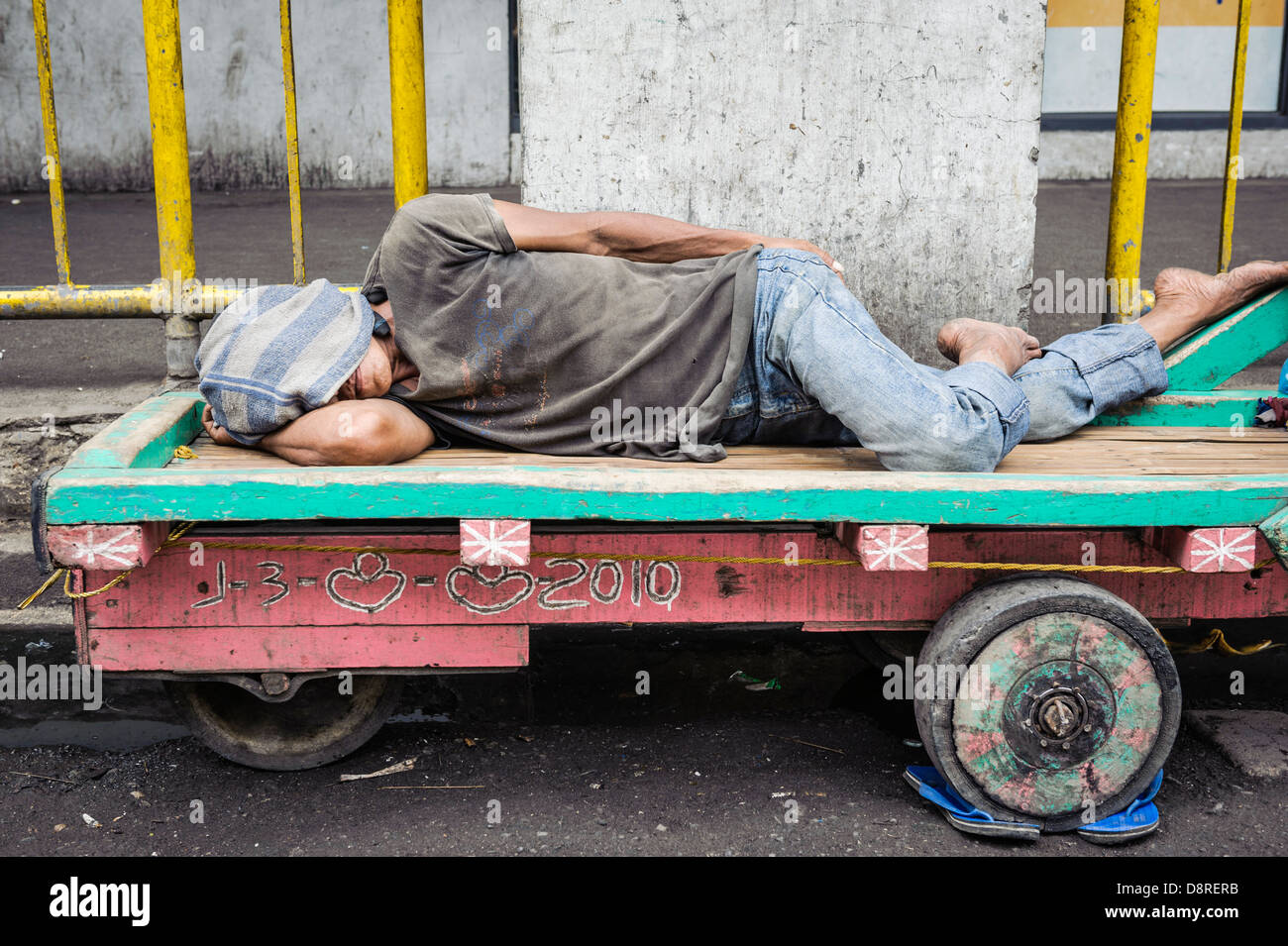 Man sleeping on a wheelbarrow, Carbon market, Visayas, Philippines ...