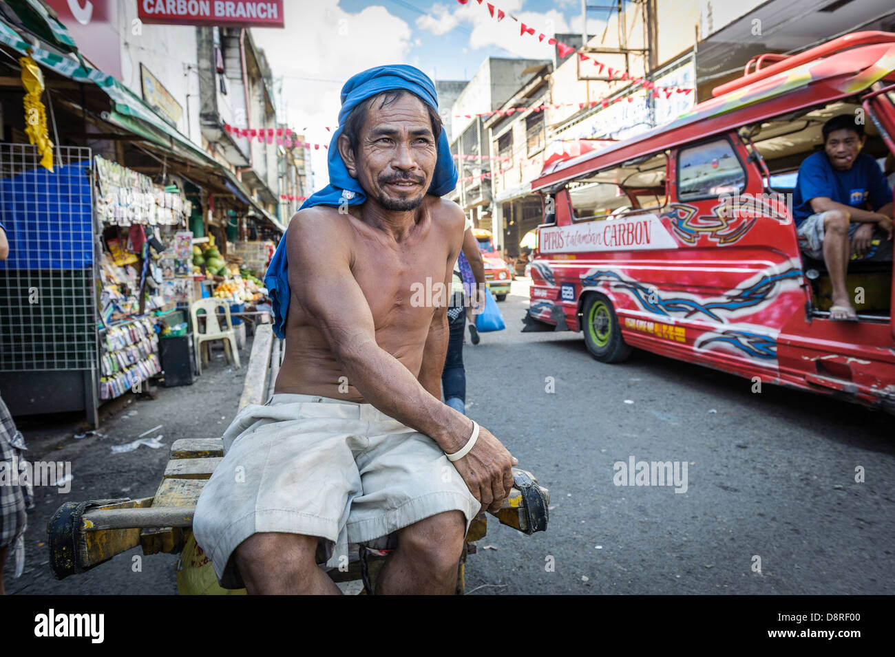 Man sitting on his wheelbarrow waiting for clients, Carbon market, Cebu ...