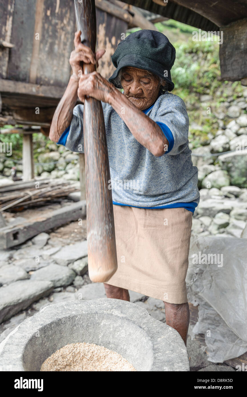Woman pounding rice in a rural village, Batad, Luzon, Philippines Stock ...