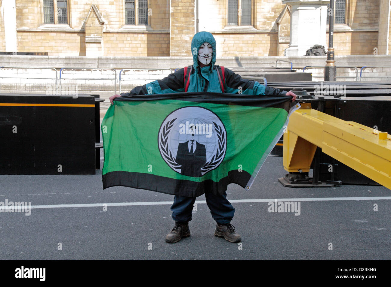 An Anonymous protester holding a green Anonymous flag, outside the ...