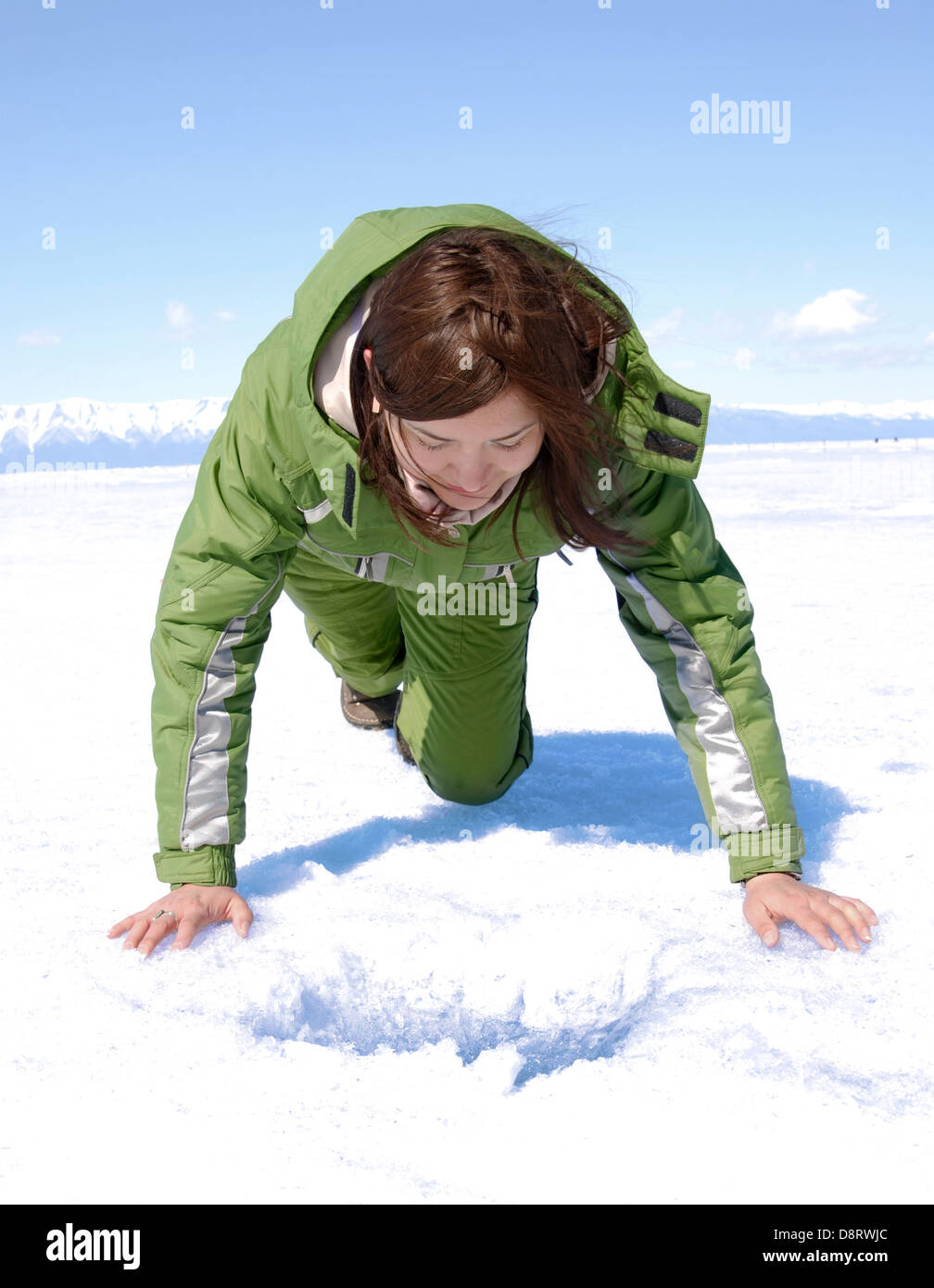 young woman looks into ice hole Stock Photo - Alamy