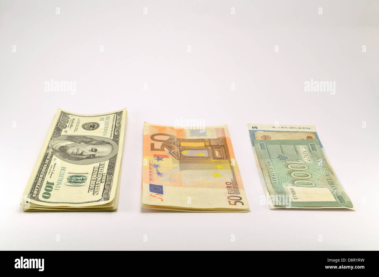 three piles of banknotes on a white background Stock Photo - Alamy