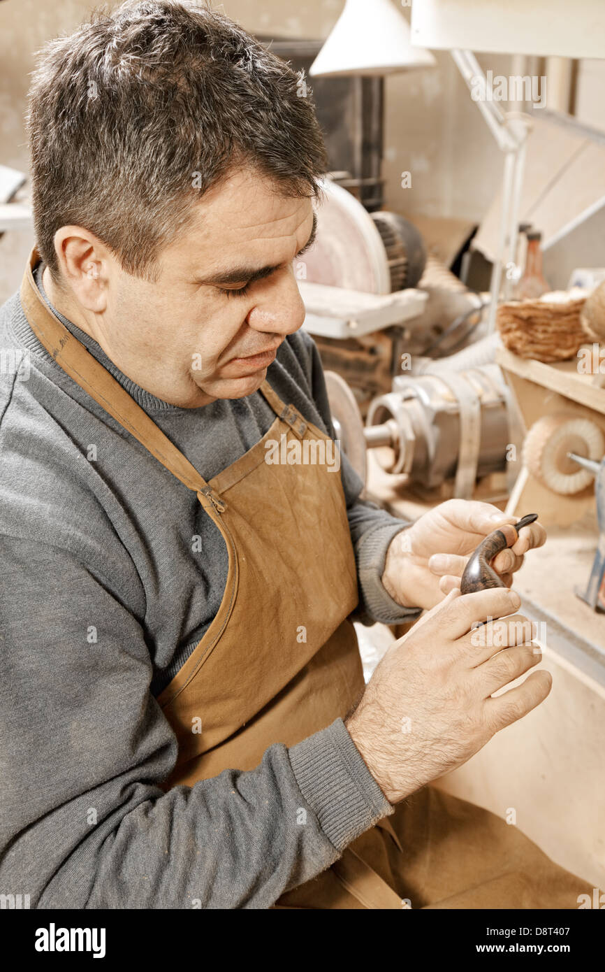 Smoking pipe maker examining finished work Stock Photo - Alamy