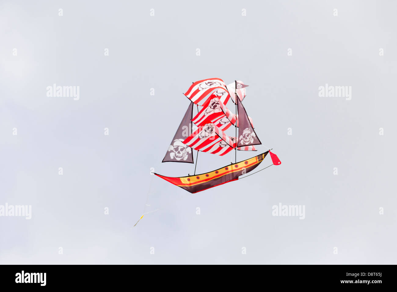 A kite, flying, in the form of a pirate ship with skull and crossbones ...
