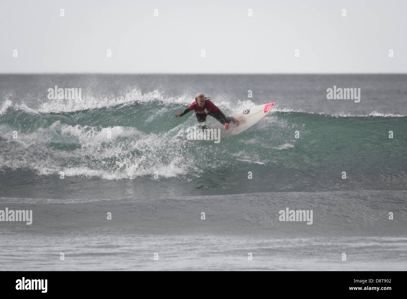 FISTRAL BEACH, NEWQUAY, CORNWALL, UK. Unknown female surfer riding a ...