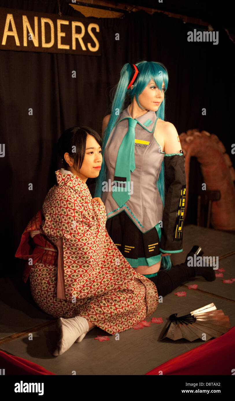 Young Japanese woman and cosplay anime performer pose for artists at a ...