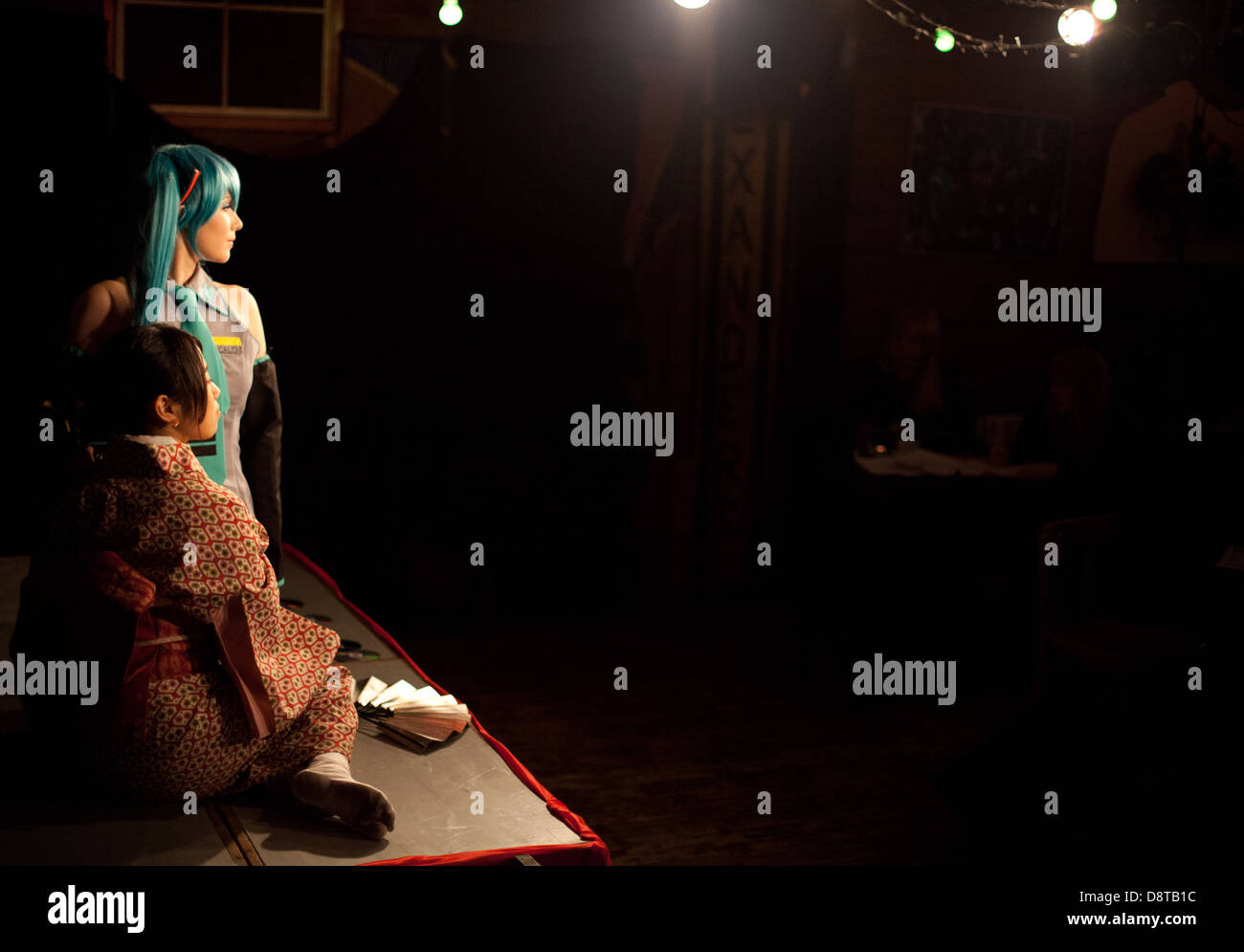 Young Japanese woman and cosplay anime performer pose for artists at a ...