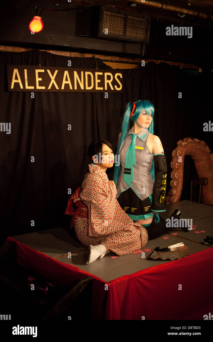 Young Japanese woman and cosplay anime performer pose for artists at a ...