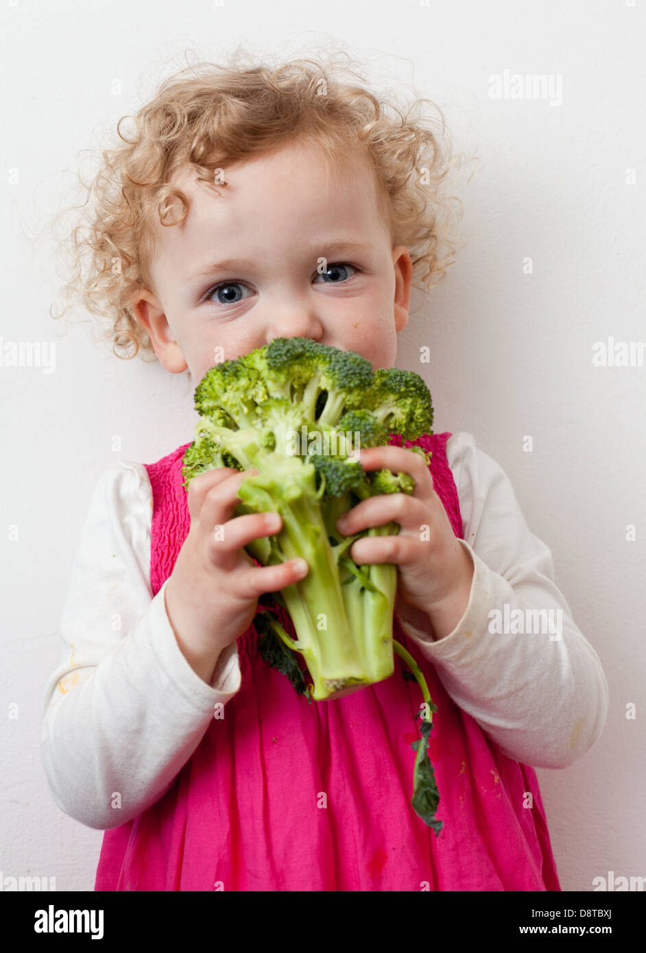 Young girl eating broccoli Stock Photo - Alamy