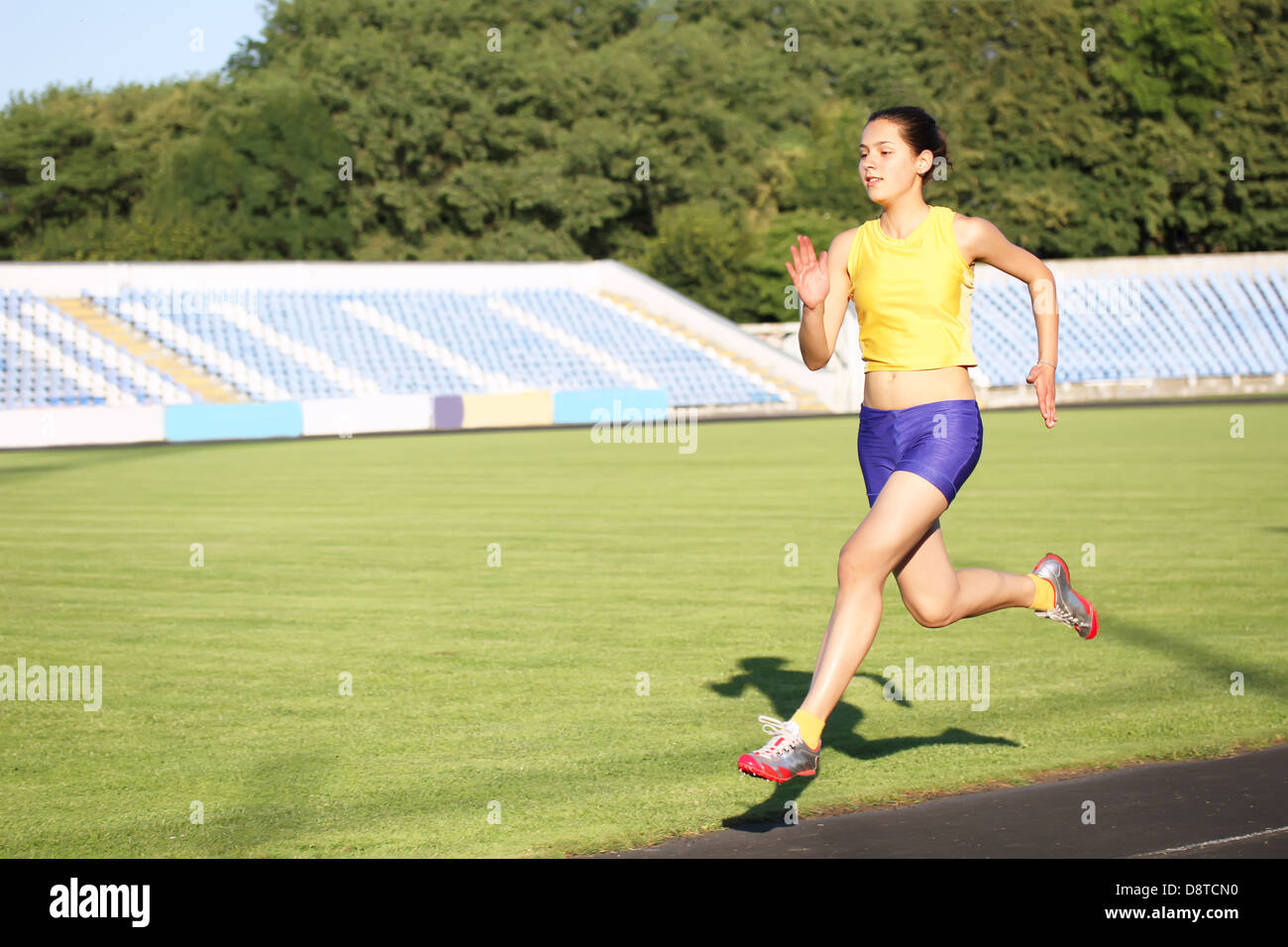 Girl running on the stadium track Stock Photo - Alamy