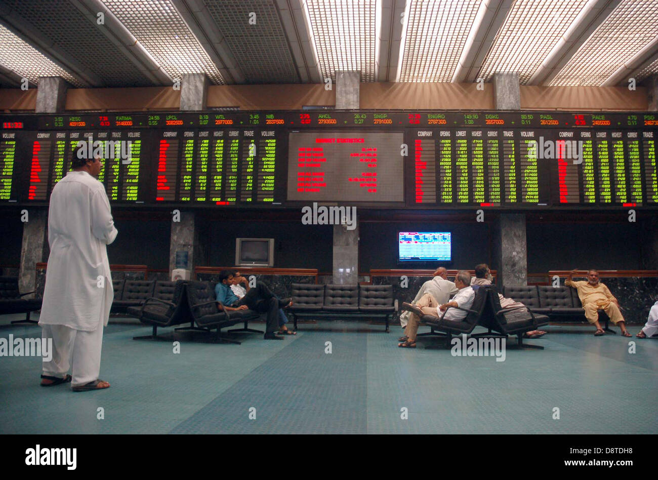 Pakistani stockbrokers look at a stock graph during a trading session ...