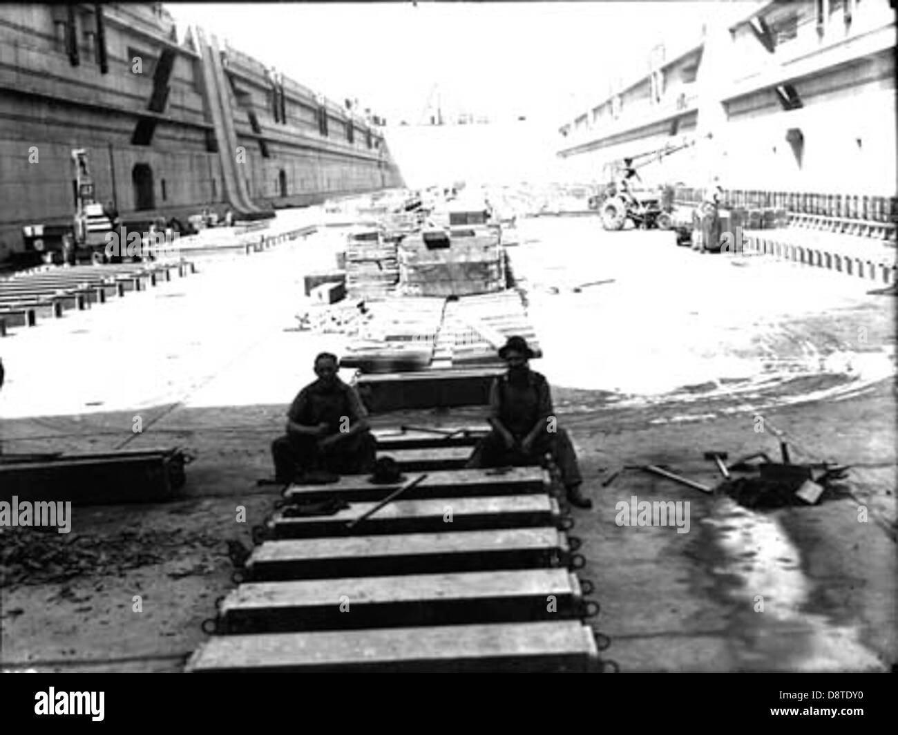 A black-and-white photograph showing workers aboard the Captain Cook ...