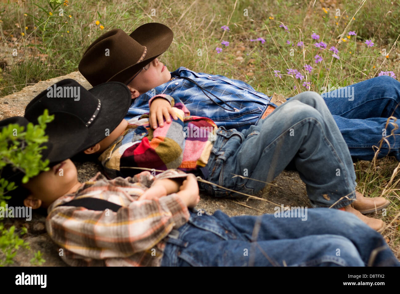 three young cowboys napping nap resting Blanco, TX / tx / Texas Stock ...